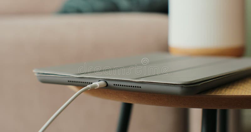 Woman Hand Inserts the Cable To Charge the TabletPC on the Table. Close ...