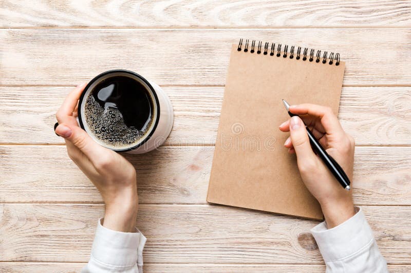 Woman Hand with Pencil Writing on Notebook and Hold Coffee Cup. Woman ...