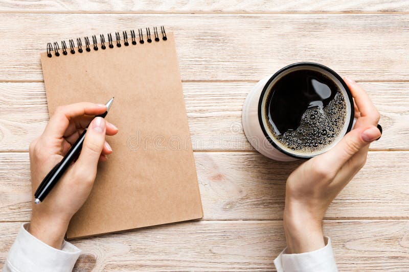 Woman Hand with Pencil Writing on Notebook and Hold Coffee Cup. Woman ...