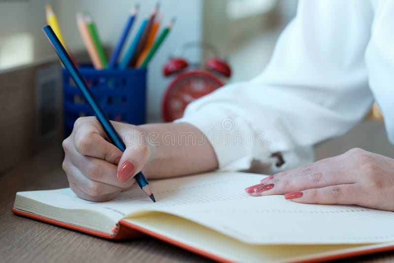 Woman Hand with Pencil Writing on Notebook. Making Notes in Notebook ...
