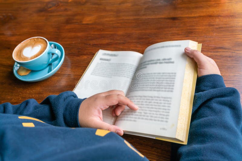 Woman Hand Reading Book and Drinking Coffee Stock Photo - Image of ...