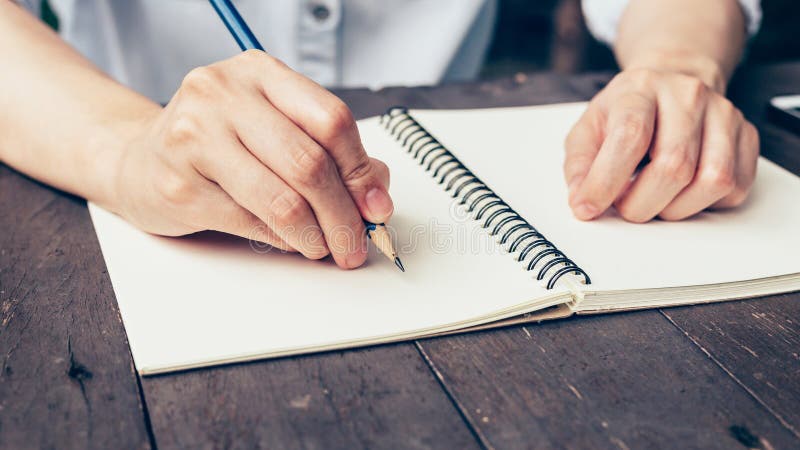 Woman Hand Writing Note Pad on Wood Table in Coffee Shop. Stock Image ...