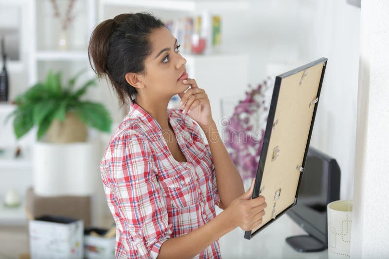 Woman Hanging Frame on Wall Stock Photo - Image of hanging, frame ...