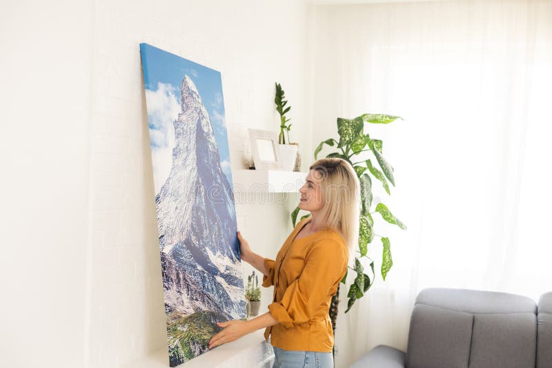 Woman Hanging a Photo Canvas on a Wall. Stock Photo - Image of empty ...