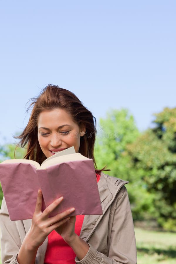 Woman Happily Reading a Book with the Wind Blowing through Her H Stock ...