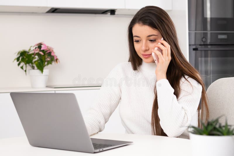 Woman Has a Call Using Smartphone while Working with Laptop at Home ...