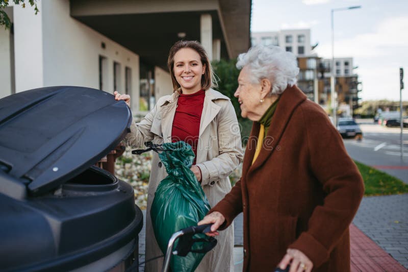 Woman Helping Elderly Neighbor Throw Away Trash into Garbage Can, Waste ...