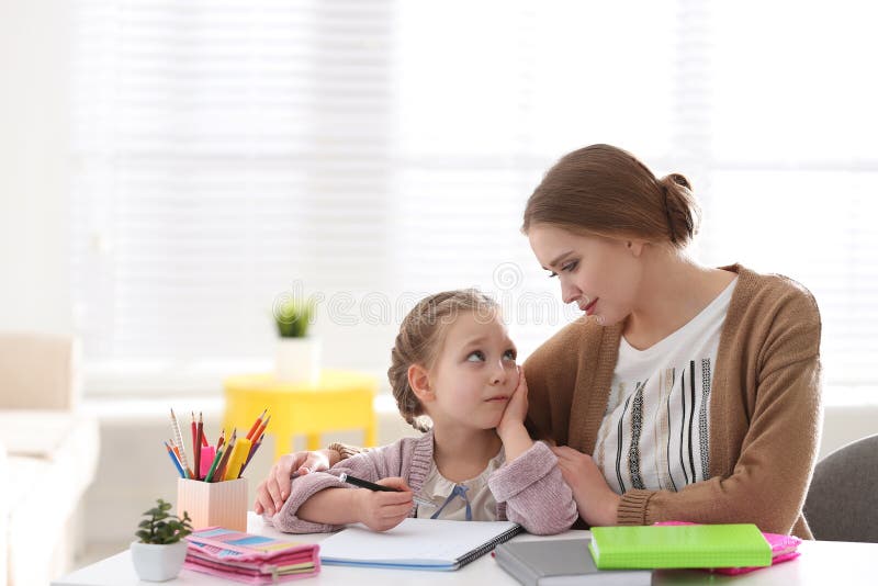 Woman Helping Her Daughter with Homework at Table Stock Photo - Image ...
