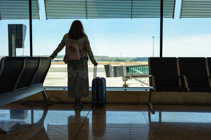 Woman with Her Back Turned Looking Out the Window while Waiting To ...