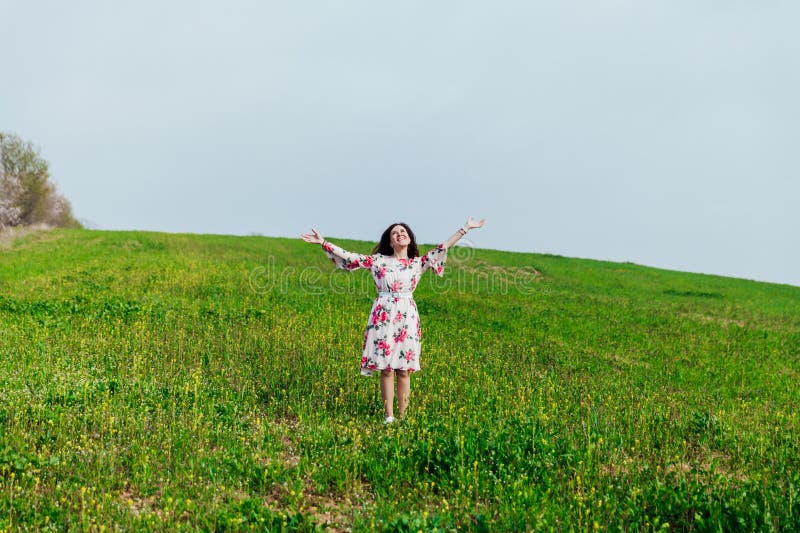 A Woman with Her Hands Up Standing on a Green Field Walk Stock Image ...