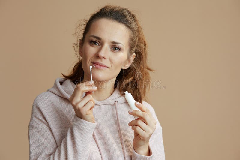Woman Applying Ointment Using Cotton Swab Against Beige Stock Image Image Of Isolated