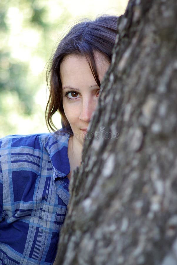Woman hides from a tree stock image. Image of joyful - 81689947