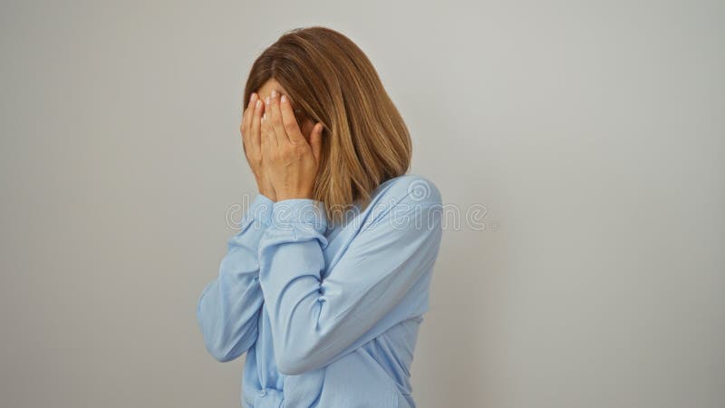 Woman Hiding Face with Hands Against a White Background, Displaying a ...