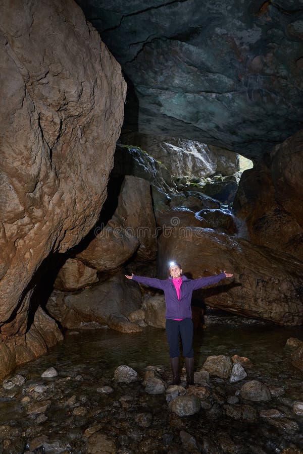 Woman hiking into a cave stock photo. Image of people - 260781968