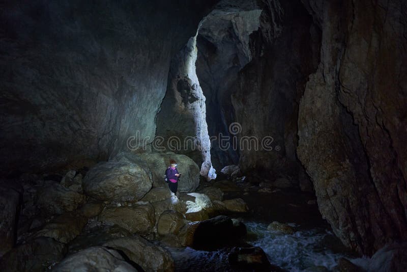 Woman hiking into a cave stock image. Image of backpack - 260781983
