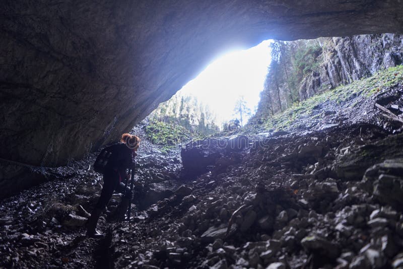 Woman hiking into a cave stock photo. Image of landscape - 260782000