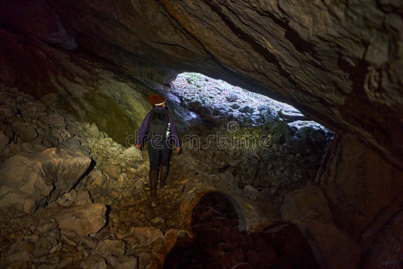 Woman hiking in a cave stock photo. Image of photographer - 260962148