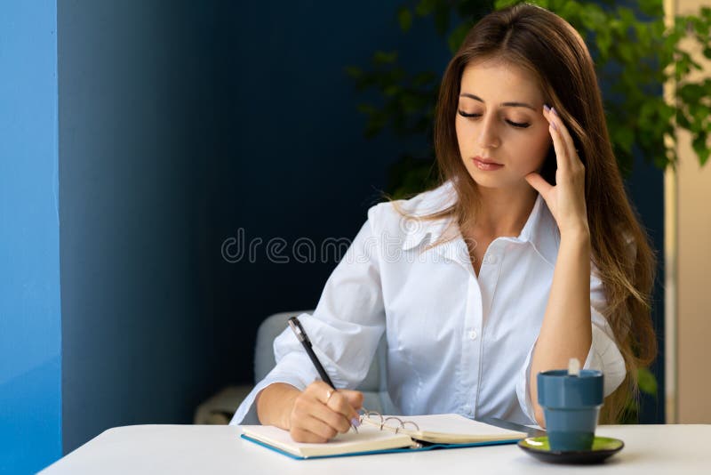 Woman Hold a Pencil Taking Notes and Drinking Coffee at the Cafe. Hand ...