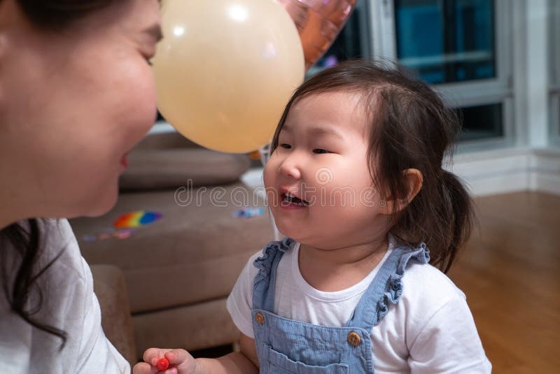 A Woman is Holding a Balloon in Front of a Child Stock Image - Image of ...