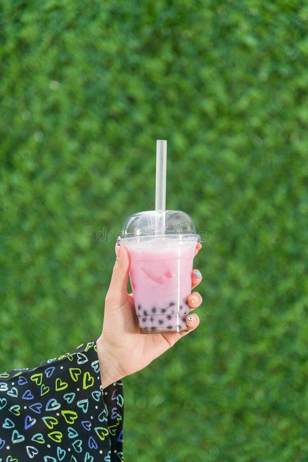 Woman Holding Bubble Tea with Lemonade in Front of Green Grass Wall ...