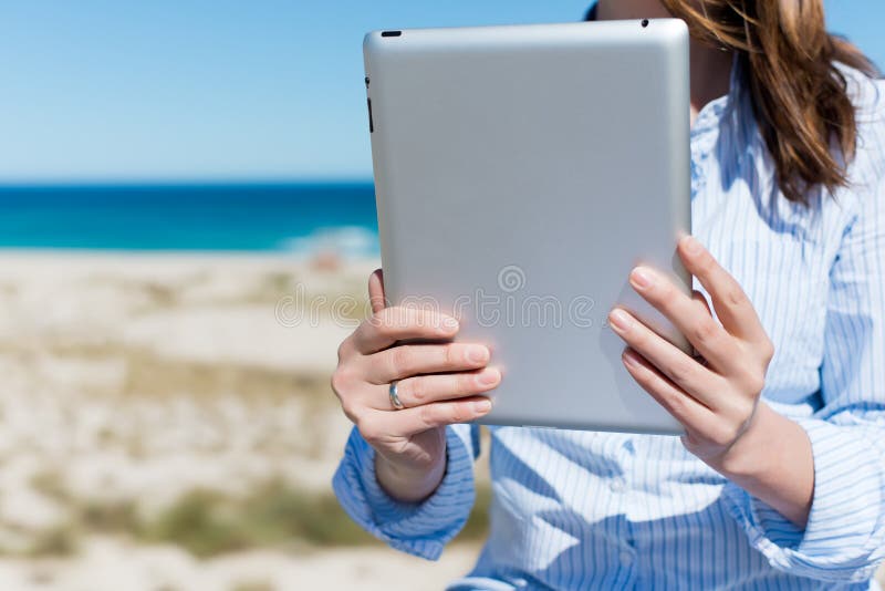 Girl Reading an Ebook or Tablet on the Beach Stock Image - Image of ...