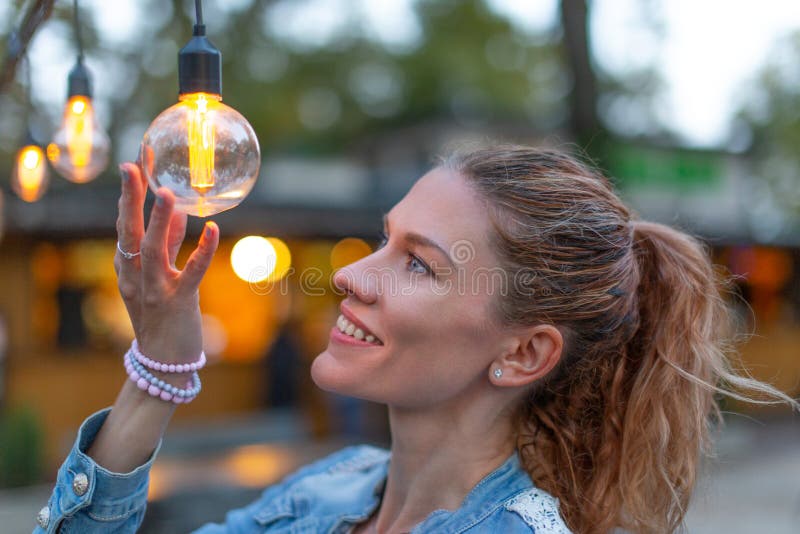 Woman Holding Energy Efficient LED String Light Bulb at Outdoors Stock ...