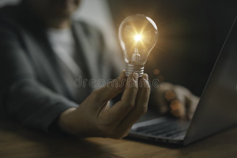 A Woman Holding Light Bulb and Using Computer Laptop for New Idea with ...