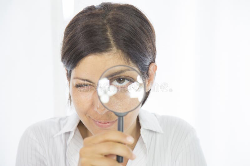 A Woman is Holding a Magnifying Glass and Looking at Her Face Stock ...