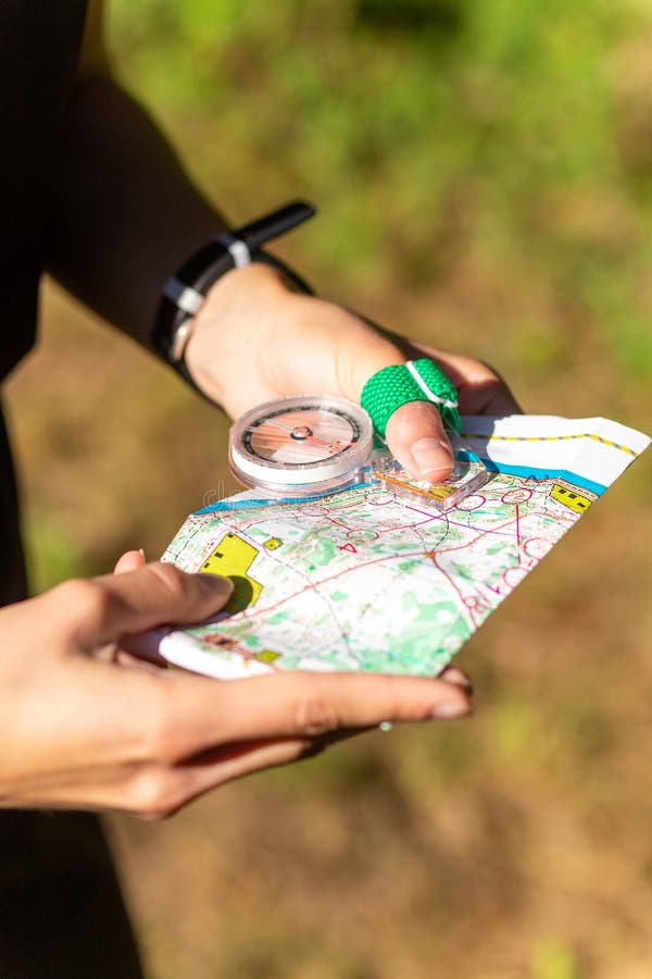 Woman Holding a Map and the Compass during Orienteering Competitions ...