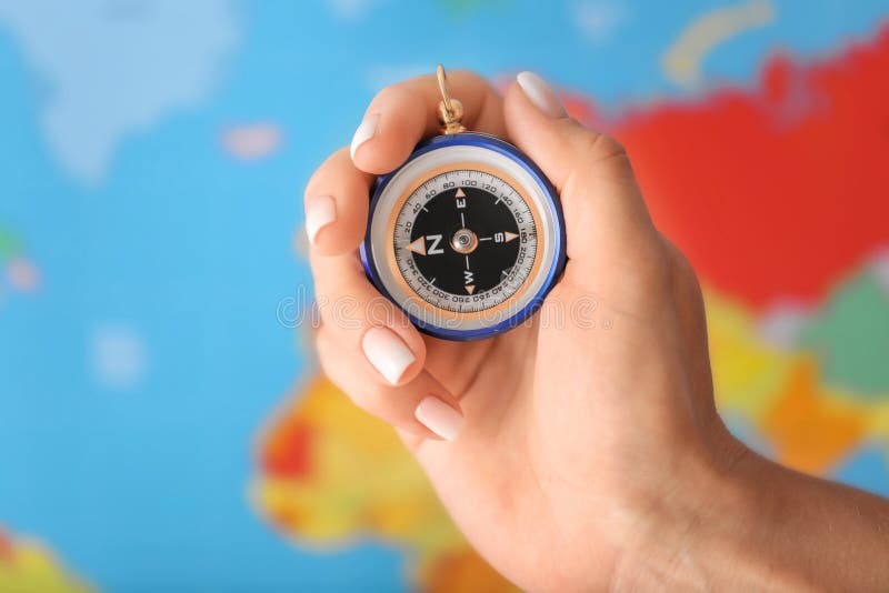 Woman Holding Modern Compass Against Blurred World Map, Closeup Stock ...