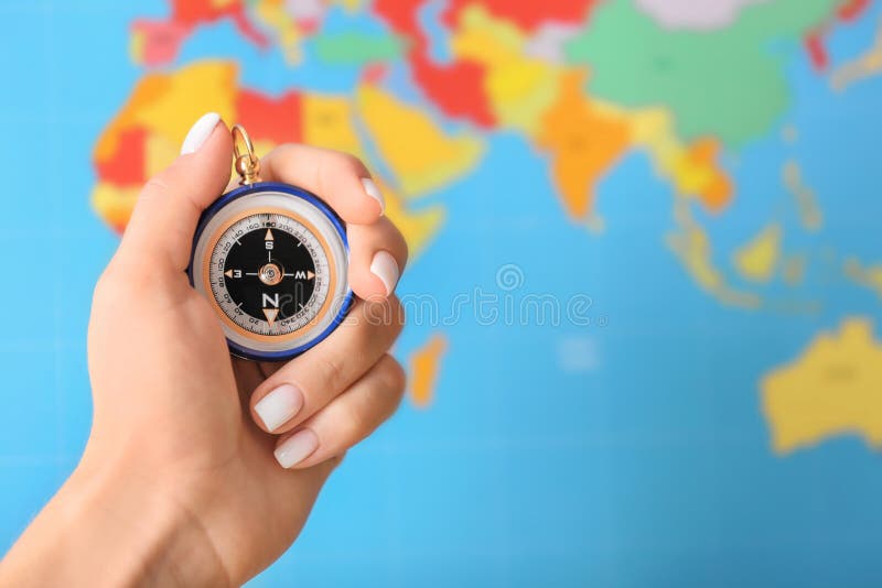 Woman Holding Modern Compass Against Blurred World Map, Closeup Stock ...