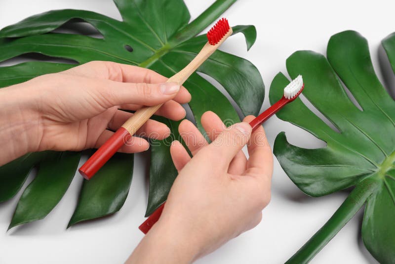 Woman Holding Natural Bamboo and Plastic Toothbrushes Above Tropical ... Woman Holding Natural Bamboo and Plastic Toothbrushes Above Tropical ...