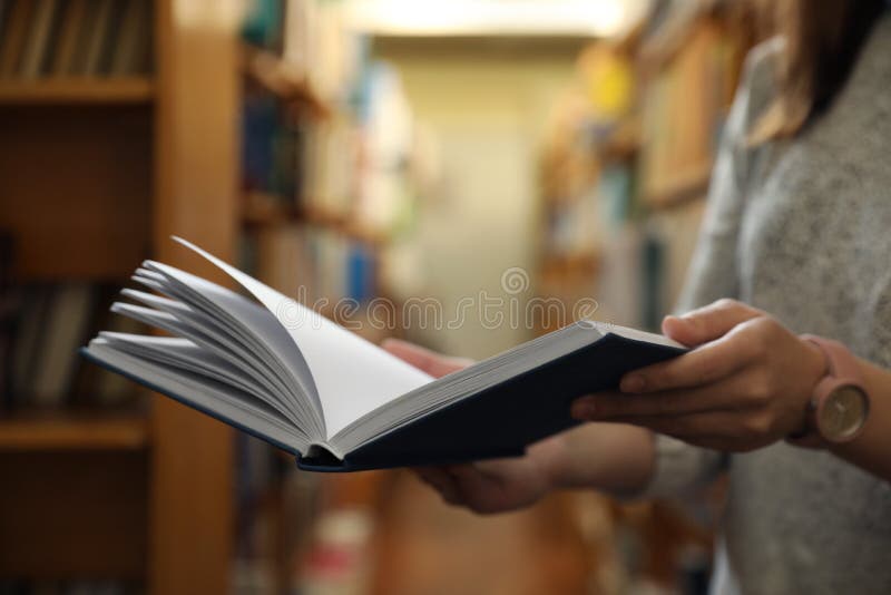Woman Holding Open Book in Library Stock Photo - Image of closeup ...