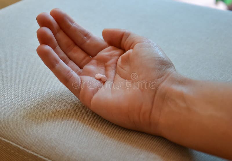 Woman holding a pink pill stock photo. Image of impotent - 196125228