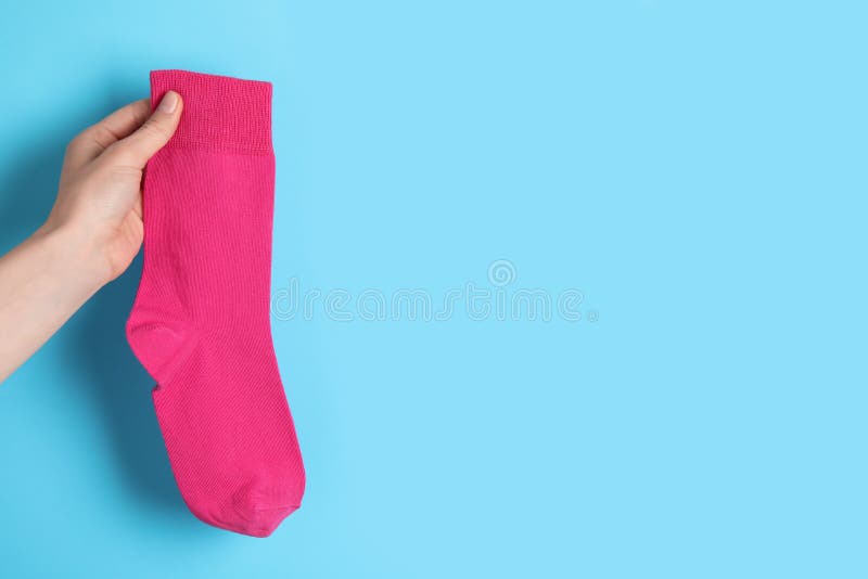 Woman Holding Pink Sock on Light Blue Background, Closeup. Space for ...