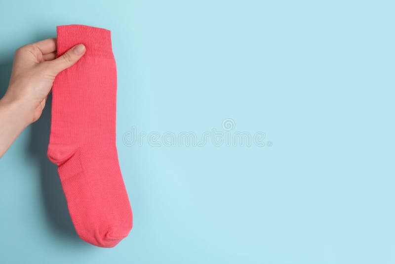 Woman Holding Pink Sock on Light Blue Background, Closeup. Space for ...