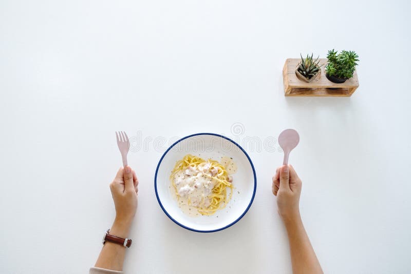 A Woman Holding Spoon And Fork Preparing To Eat Carbonara Spaghetti On