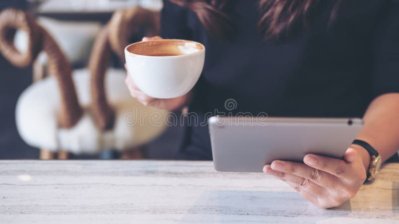 Woman Holding and Using Tablet Pc while Drinking Coffee Stock Image ...