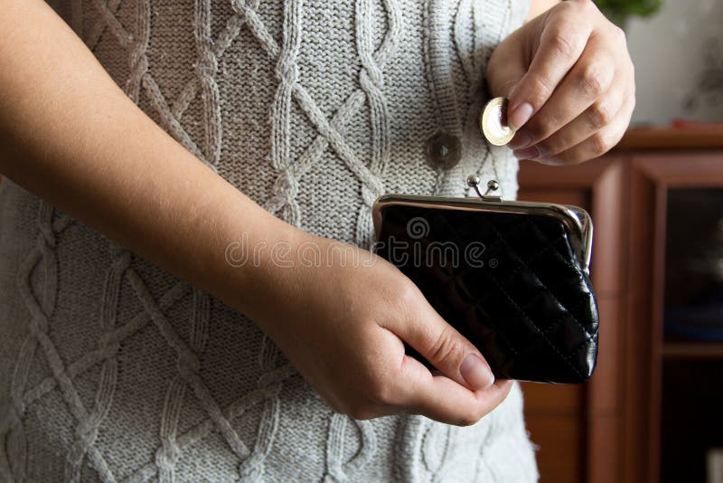 The Woman Holds the Coins Over the Old Empty Wallet. the Concept Stock ...