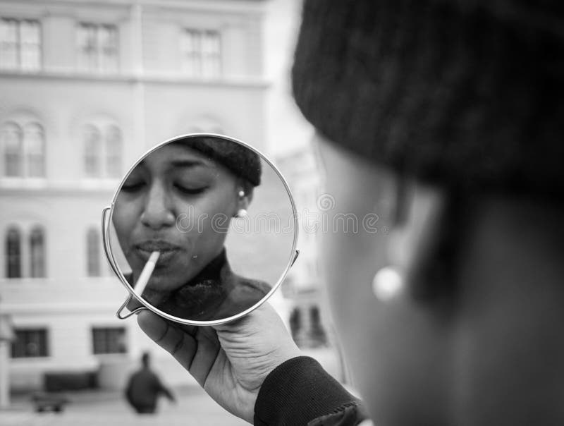 A Woman Holds a Small Mirror while Smoking Stock Photo - Image of hand ...