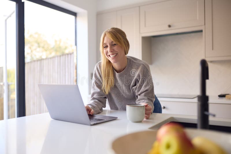 Woman at Home Working on Laptop on Counter in Kitchen Stock Image ...
