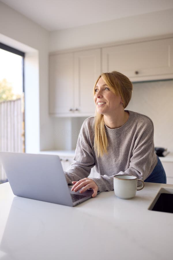 Woman at Home Working on Laptop on Counter in Kitchen Stock Photo ...