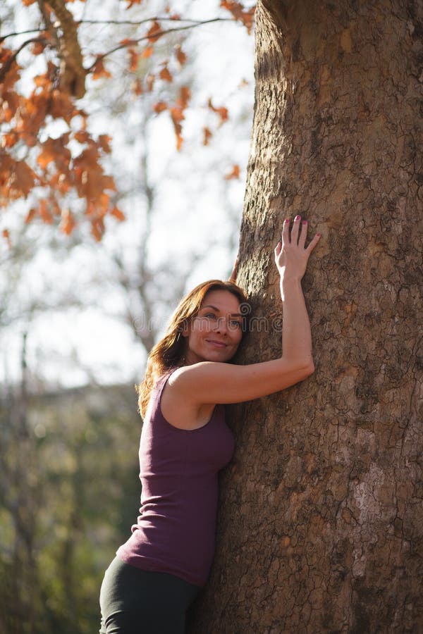 Woman Hugging a Tree in the Park after Exercise Stock Photo - Image of ...