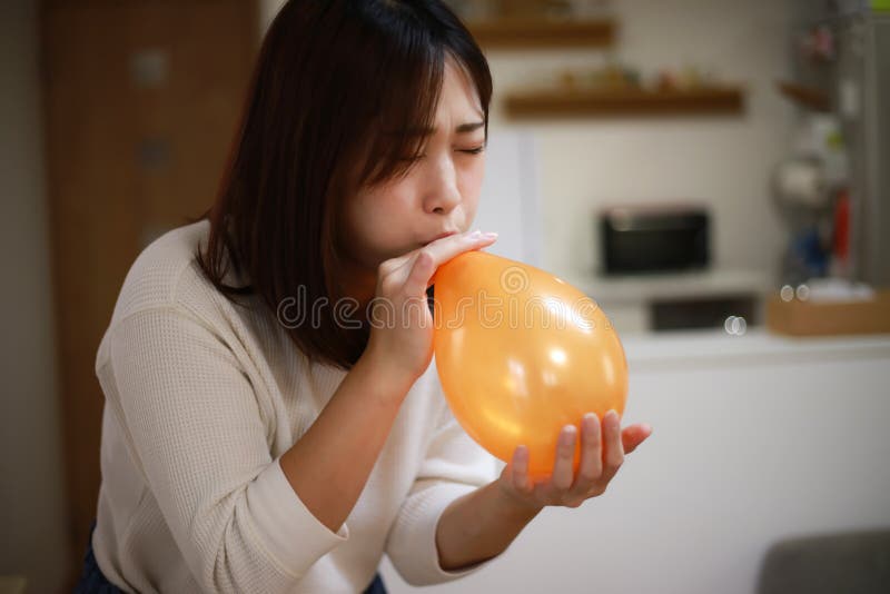 Woman inflating a balloon stock image. Image of playing - 244452865