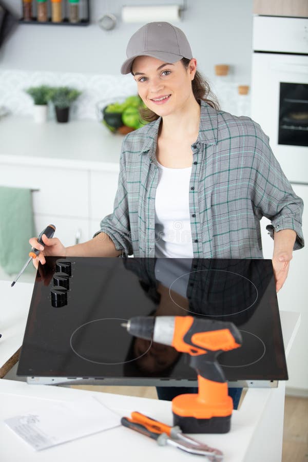Woman Installing Hob in Kitchen Stock Image - Image of slide ...