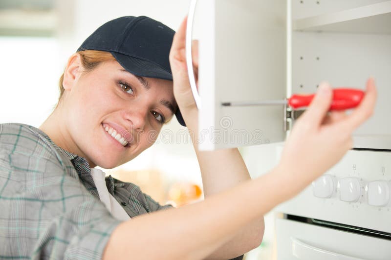 Woman Installing Kitchen Cupboard Stock Image - Image of woman ...