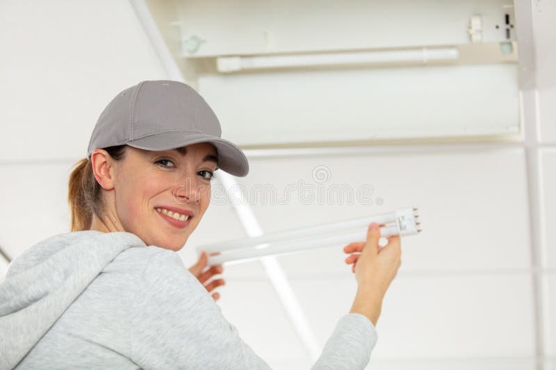 Woman Installing Replacement Fluorescent Bulb Stock Photo - Image of ...