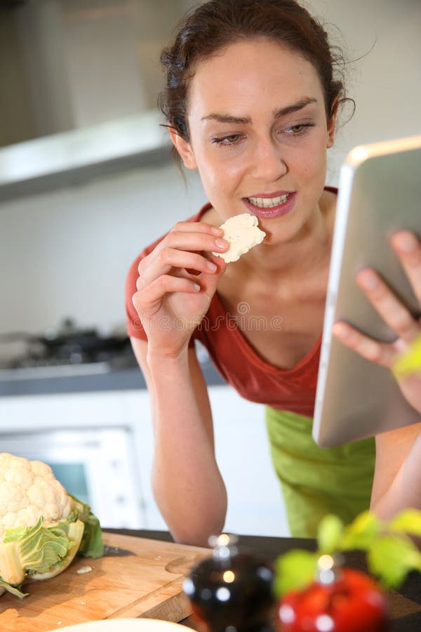 Woman in Kitchen Having a Snack and Using Tablet Stock Photo - Image of ...