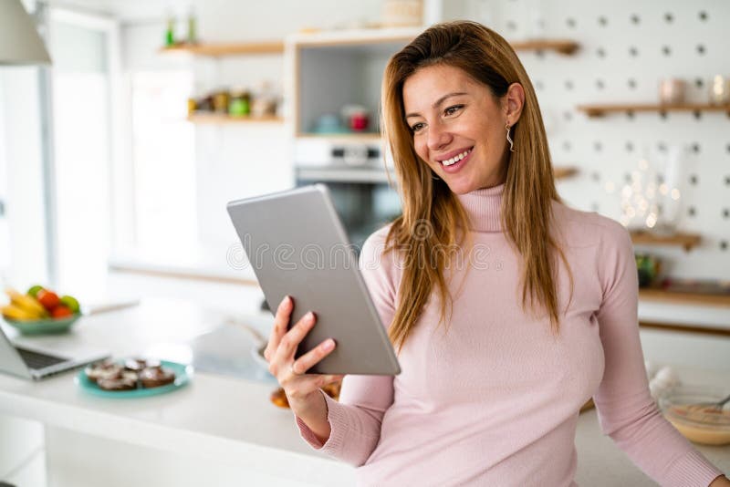 Woman in Kitchen Looking at Recipe on Tablet Stock Photo - Image of ...