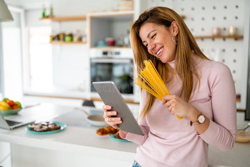 Woman in Kitchen Looking at Recipe on Tablet Stock Image - Image of ...